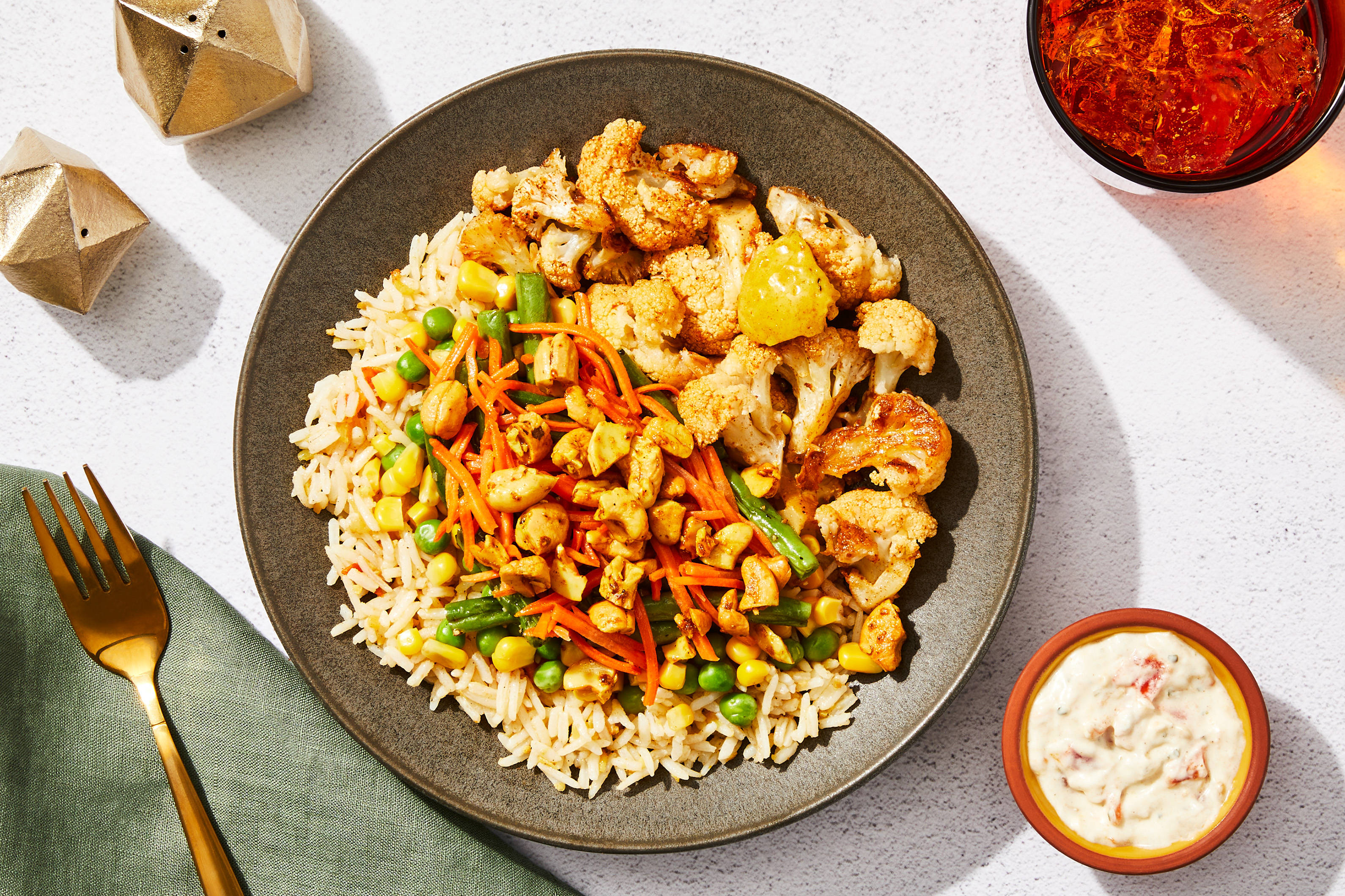 Vegetarisk biryani med ris, tandoorikryddad blomkål i curry- och ...